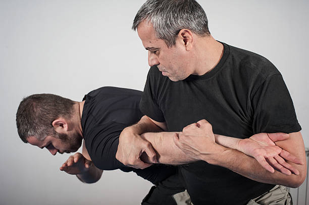 Kapap instructor demonstrates arm bar techniques with his student ...